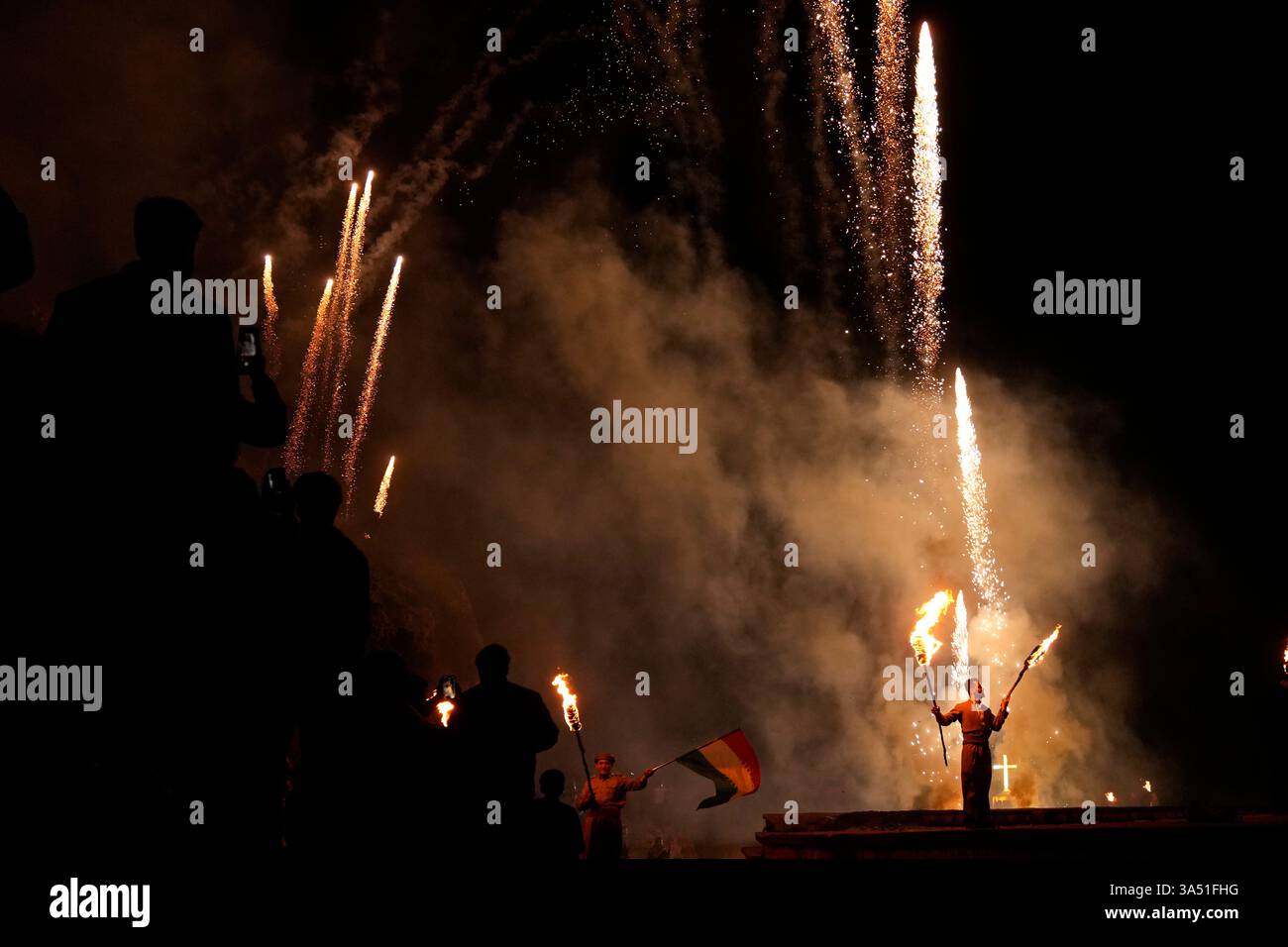 Iraqi Kurds holding lit torches walk up a mountain during a procession ...