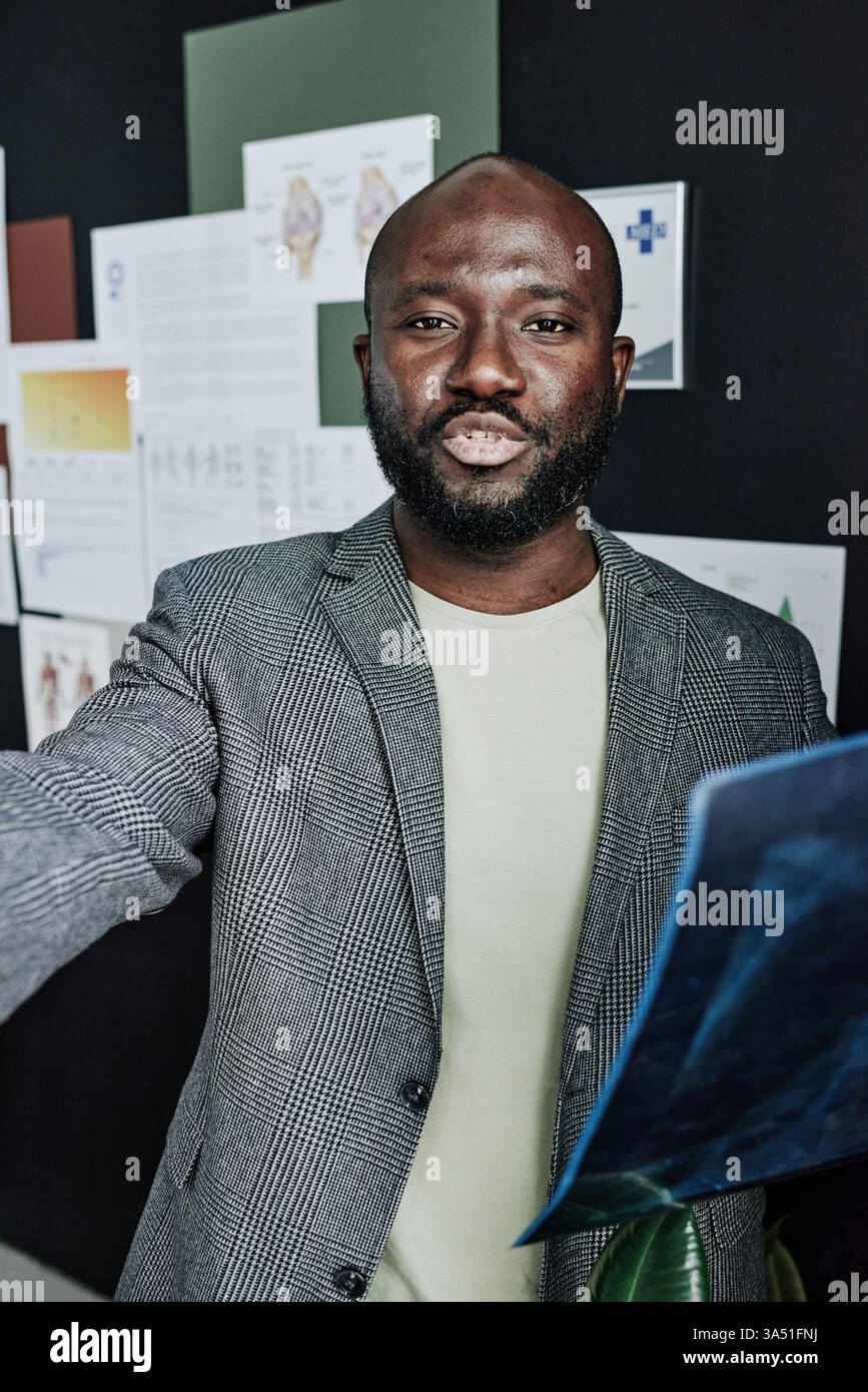 Portrait of African male radiologist working with x-ray images at ...