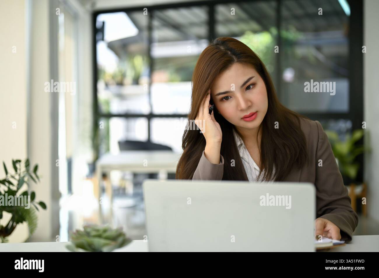 Stressed and focused millennial Asian businesswoman looking at her ...