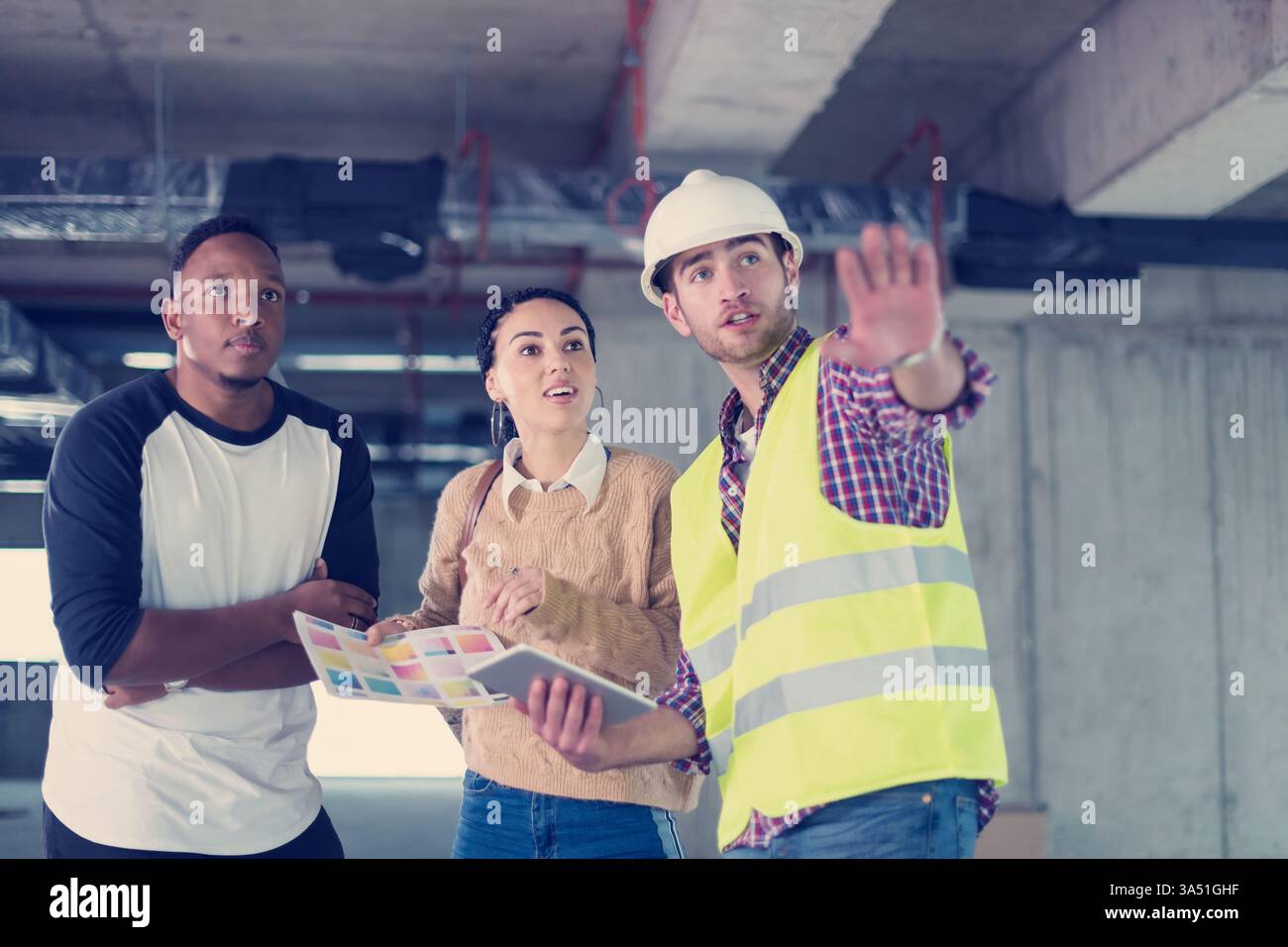 Architect or engineer uses a tablet to show house plans to a young ...