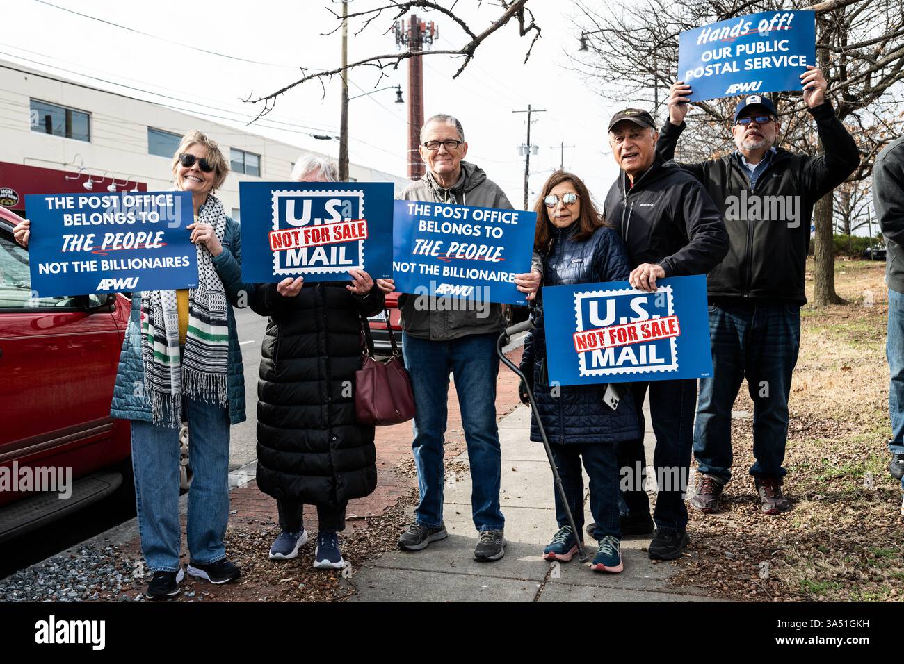 People holding signs saying "The Post Office belongs to the people, not ...