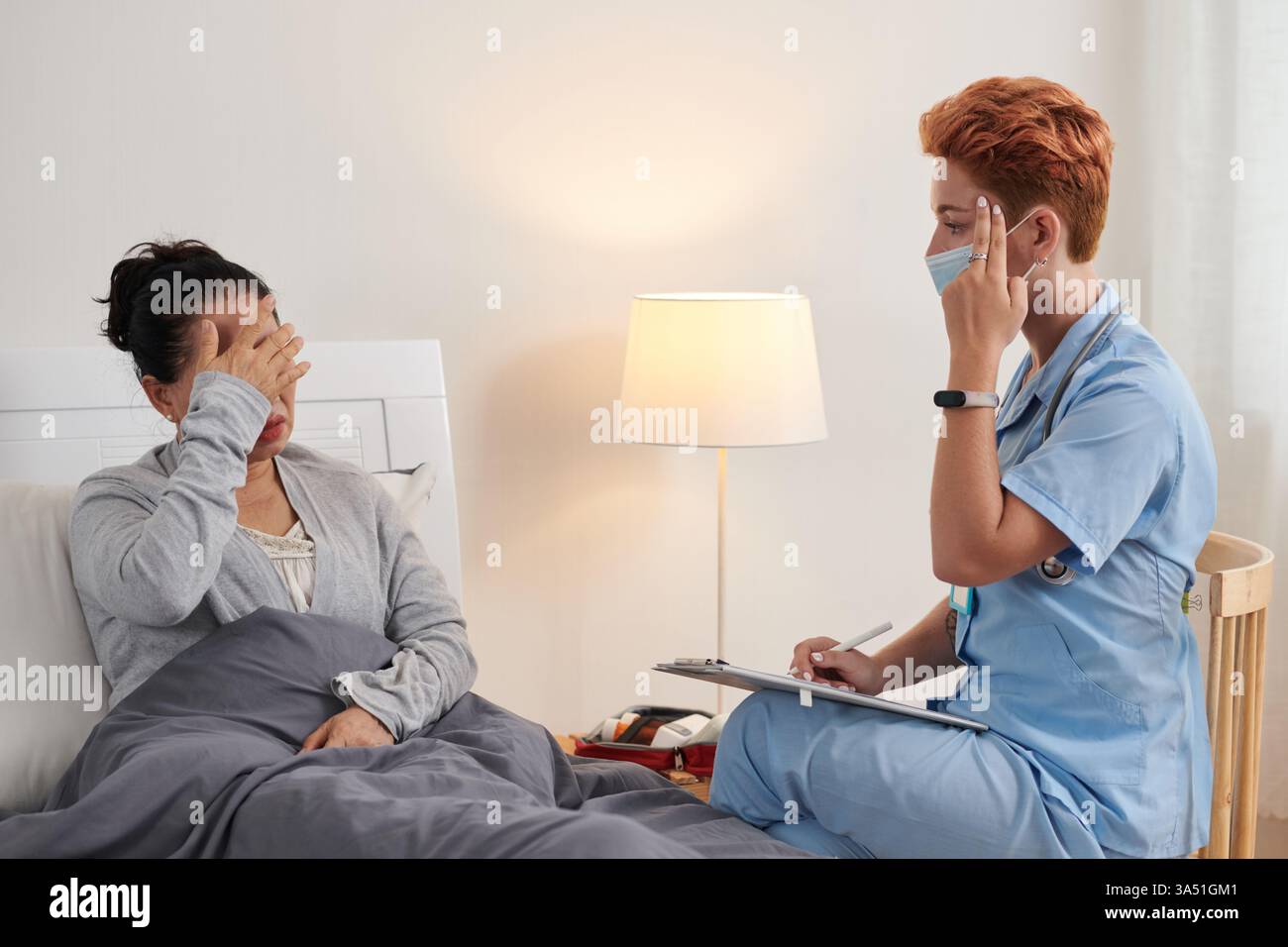 Physician asking senior woman describe headache she is suffering from ...