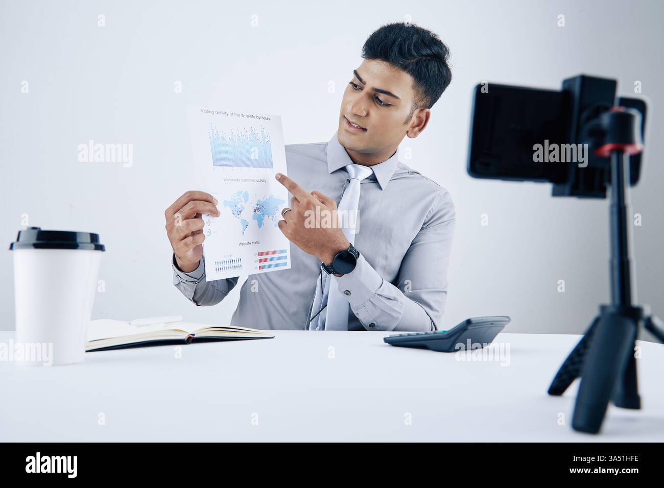 Young Indian businessman showing chart and explaining details when ...