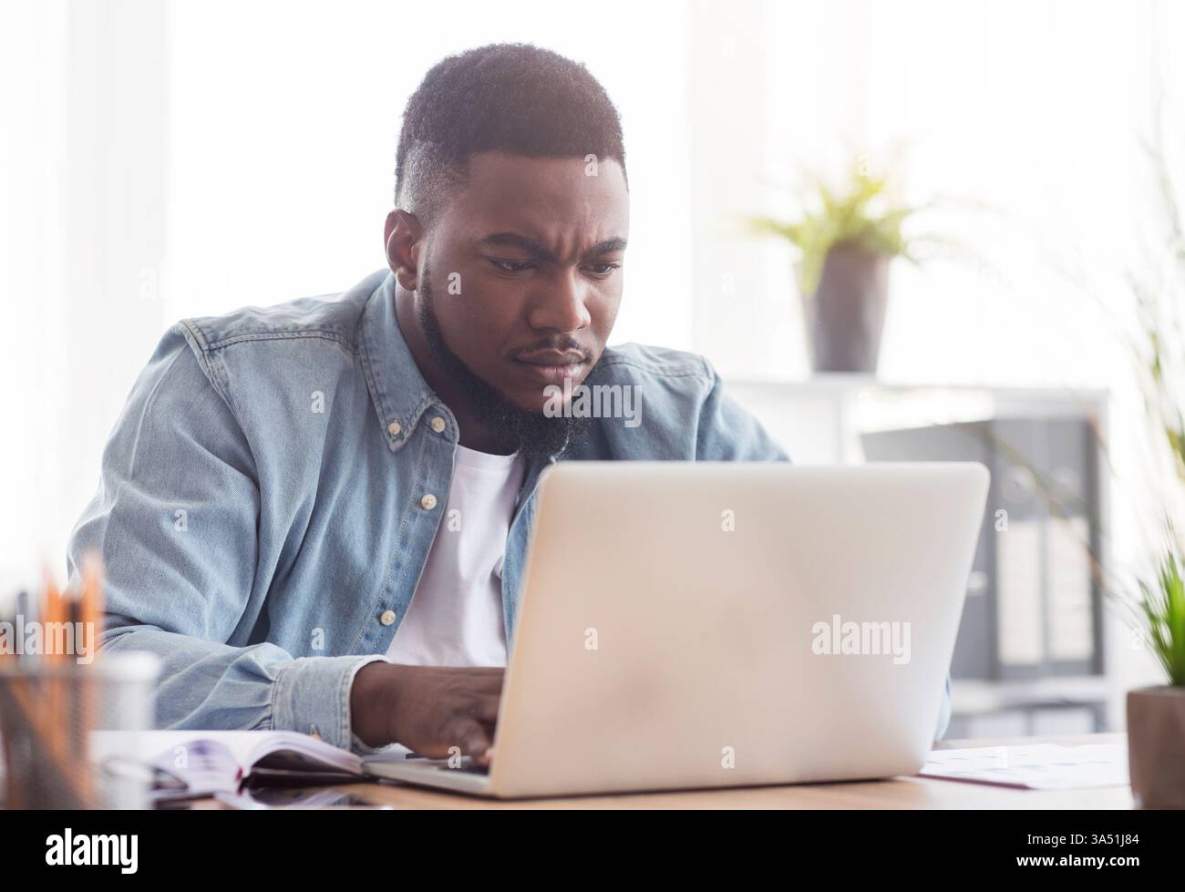 Important task. Focused african american employee working on laptop in ...
