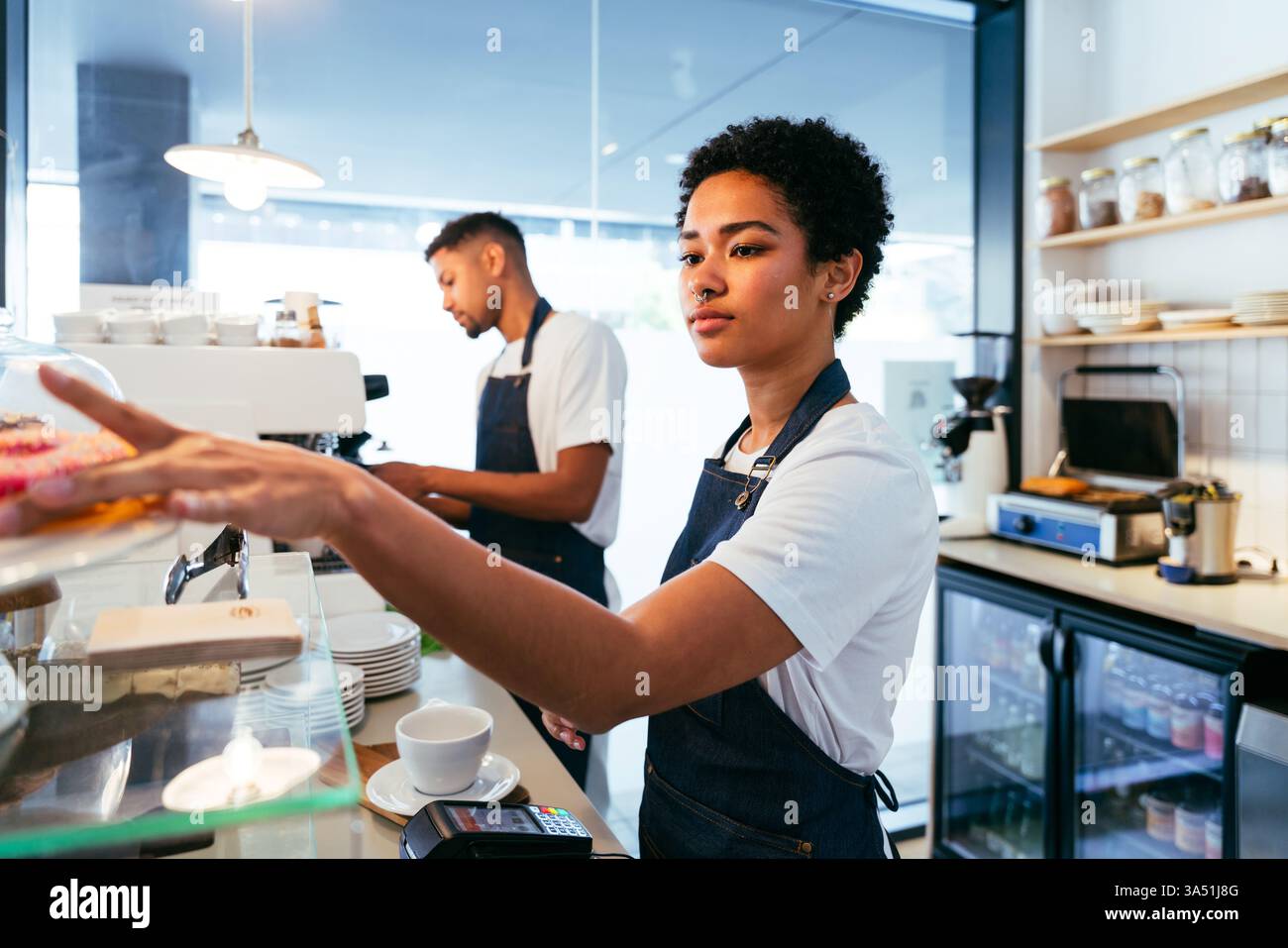 Diverse group of baristas wearing apron working together at kitchen in ...