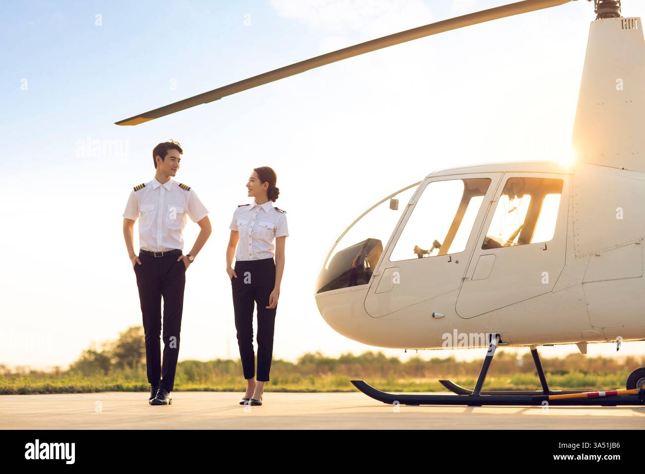 Serious Chinese male and female helicopter pilots standing by the ...