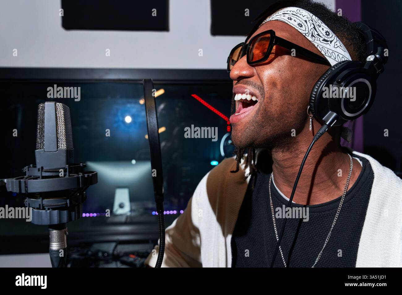 African American male singer in headphones and sunglasses recording ...