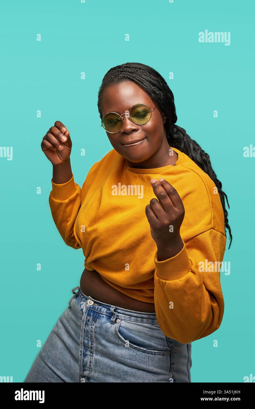 Black woman dancing snapping fingers with closed eyes against blue ...