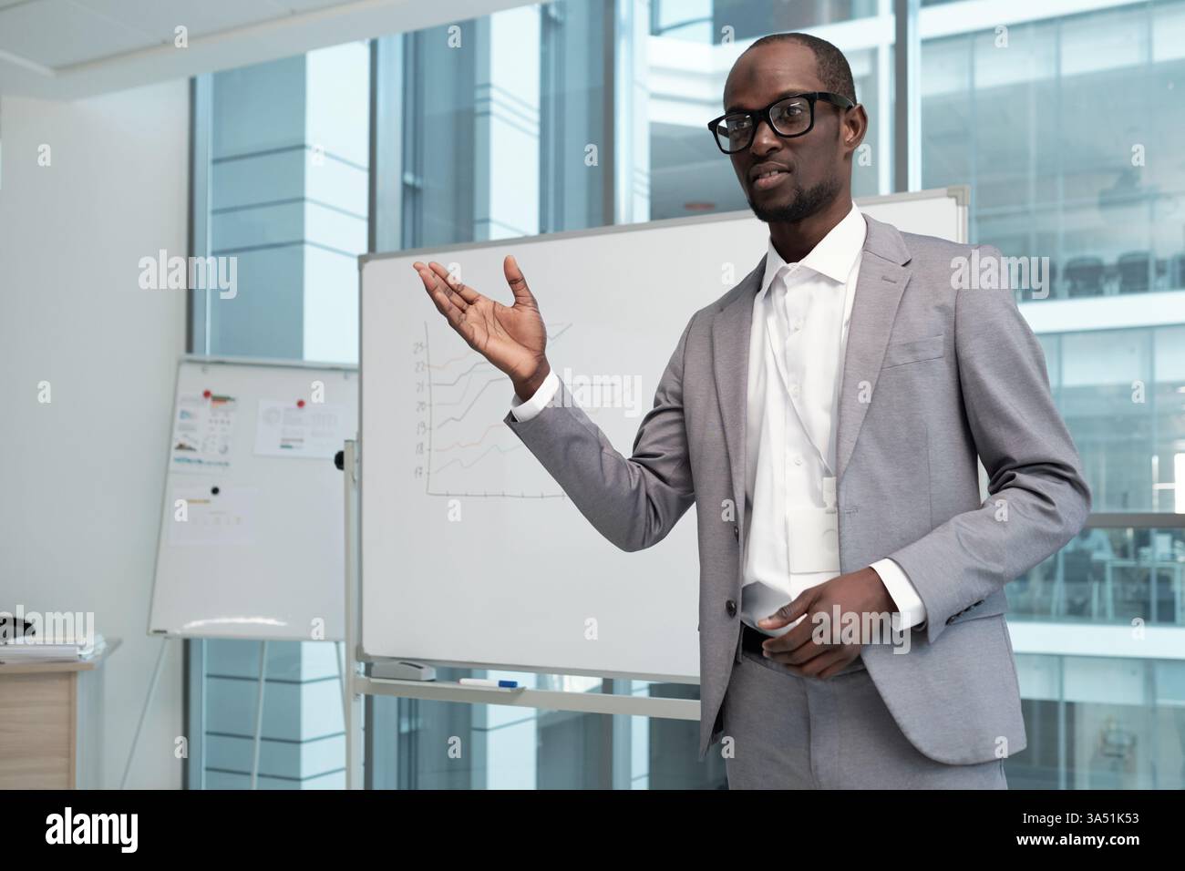 Young confident male teacher explaining audience financial information ...