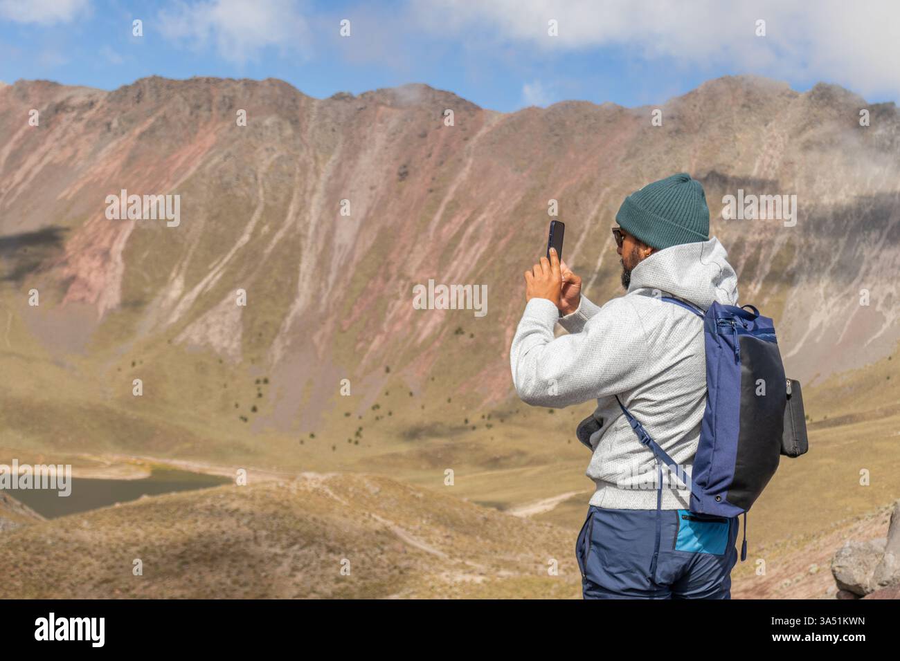 Side view of young male hiker in sunglasses warm clothes looking at ...