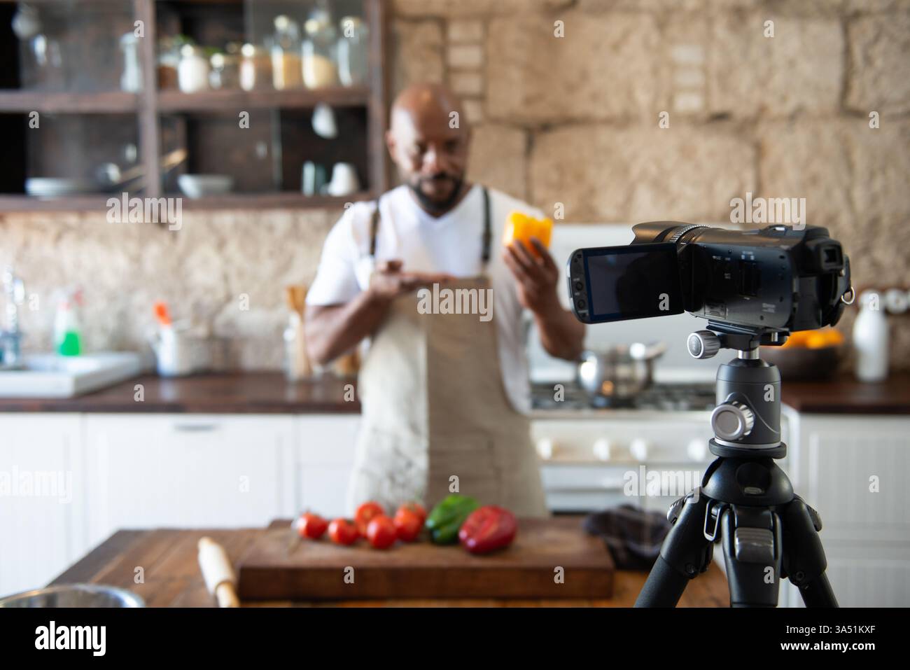 Serious Black man recording video showing yellow bell pepper standing ...