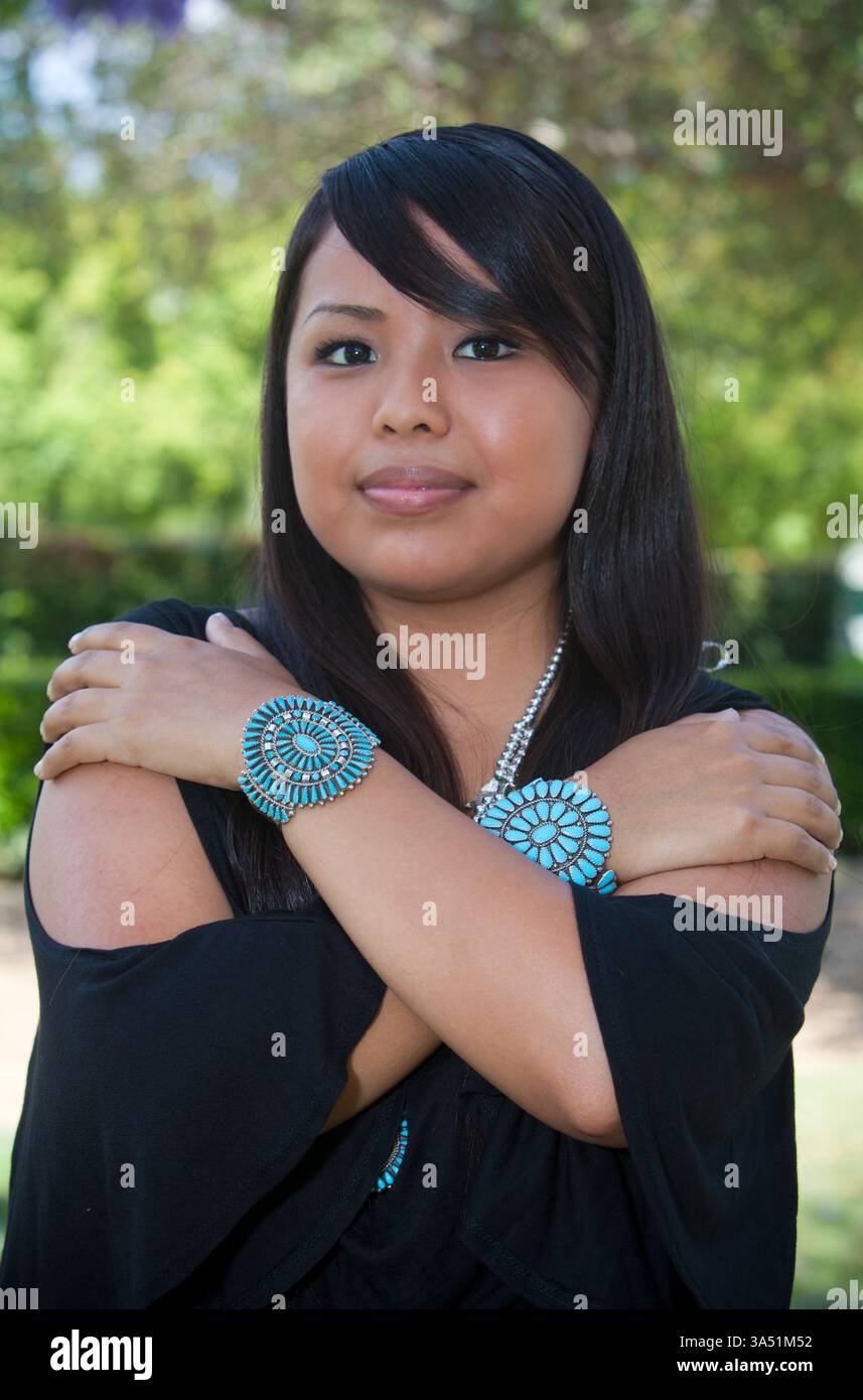 Smiling Native American woman wearing turquoise jewelry standing with ...