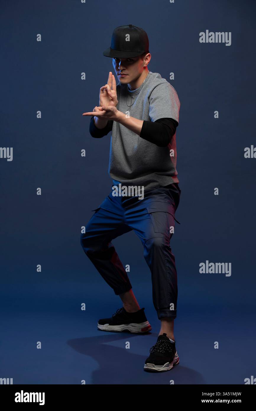 Chinese male doing karate pose against blue background in dark studio ...