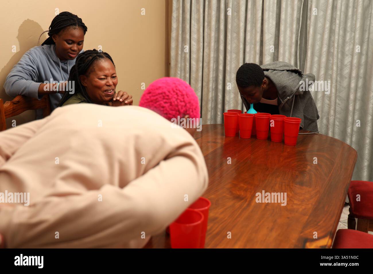 Smiling Black woman sitting with clasped hands looking at Black ...