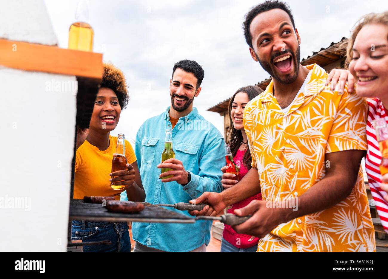 Cheerful diverse group of friends standing together and drinking beer ...