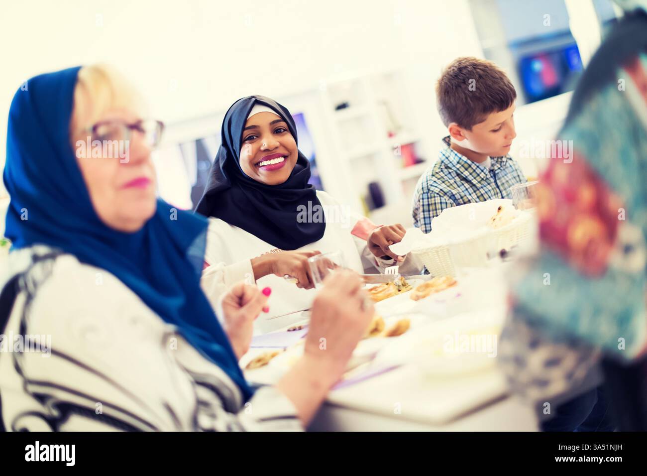 Modern African American Muslim woman enjoying iftar dinner with a ...