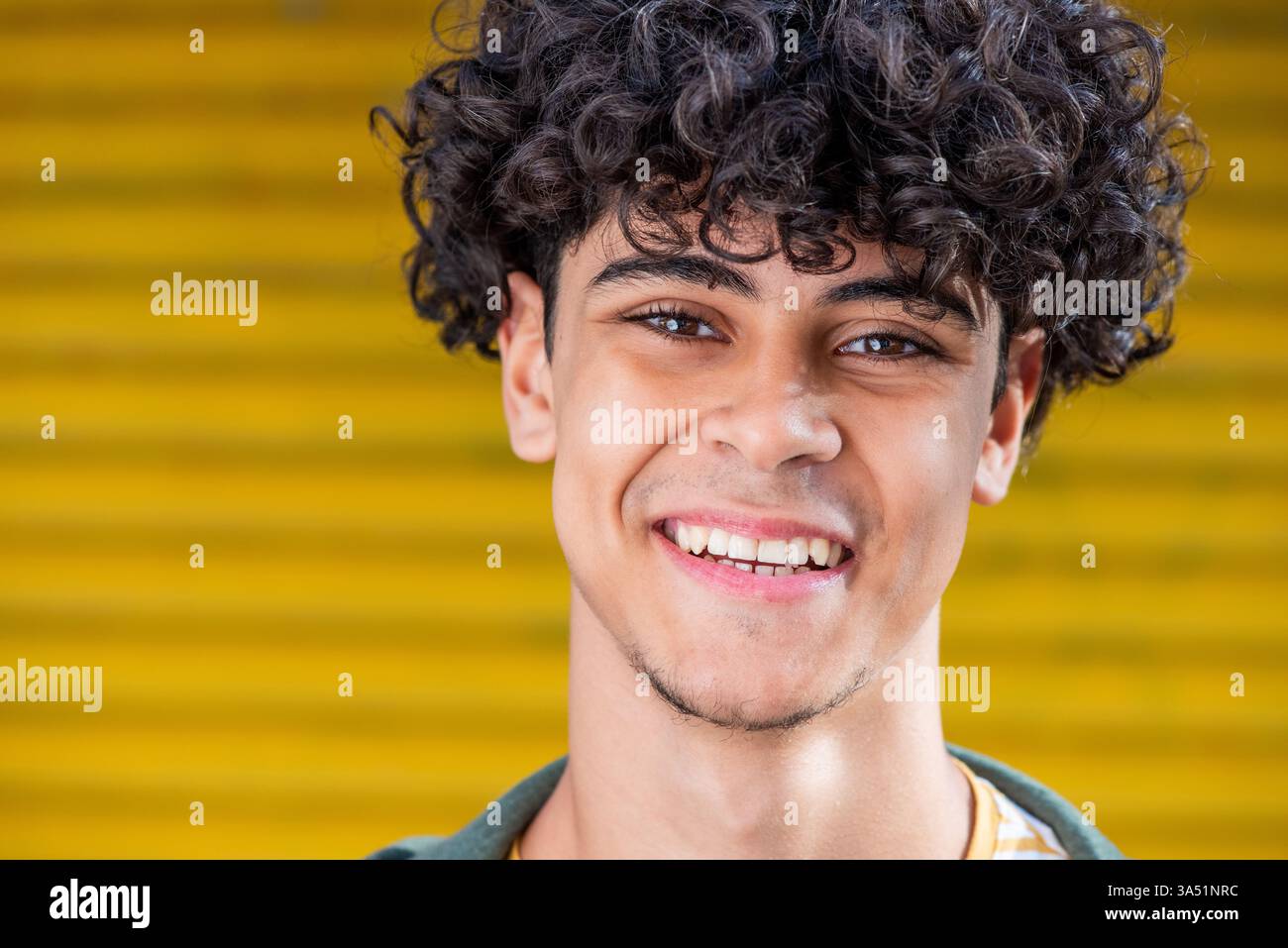 Close up portrait young North African man smiling against yellow ...