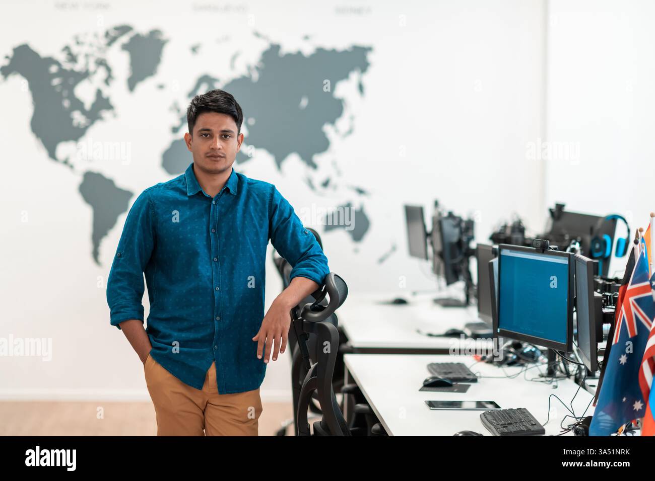 Middle Eastern man with hand in pocket leaning arm on chair standing in ...
