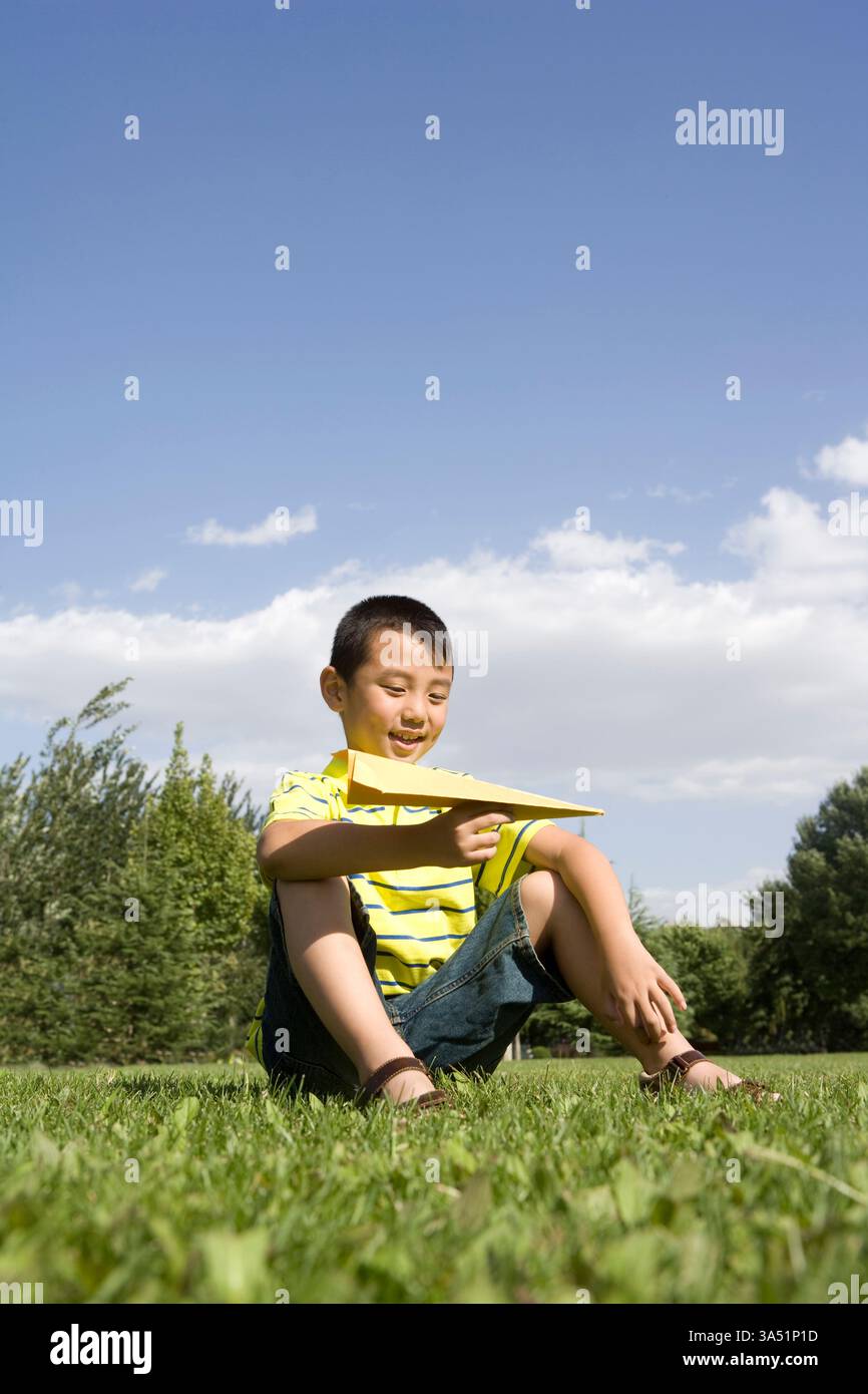 Chinese boy playing with a paper airplane Stock Photo - Alamy