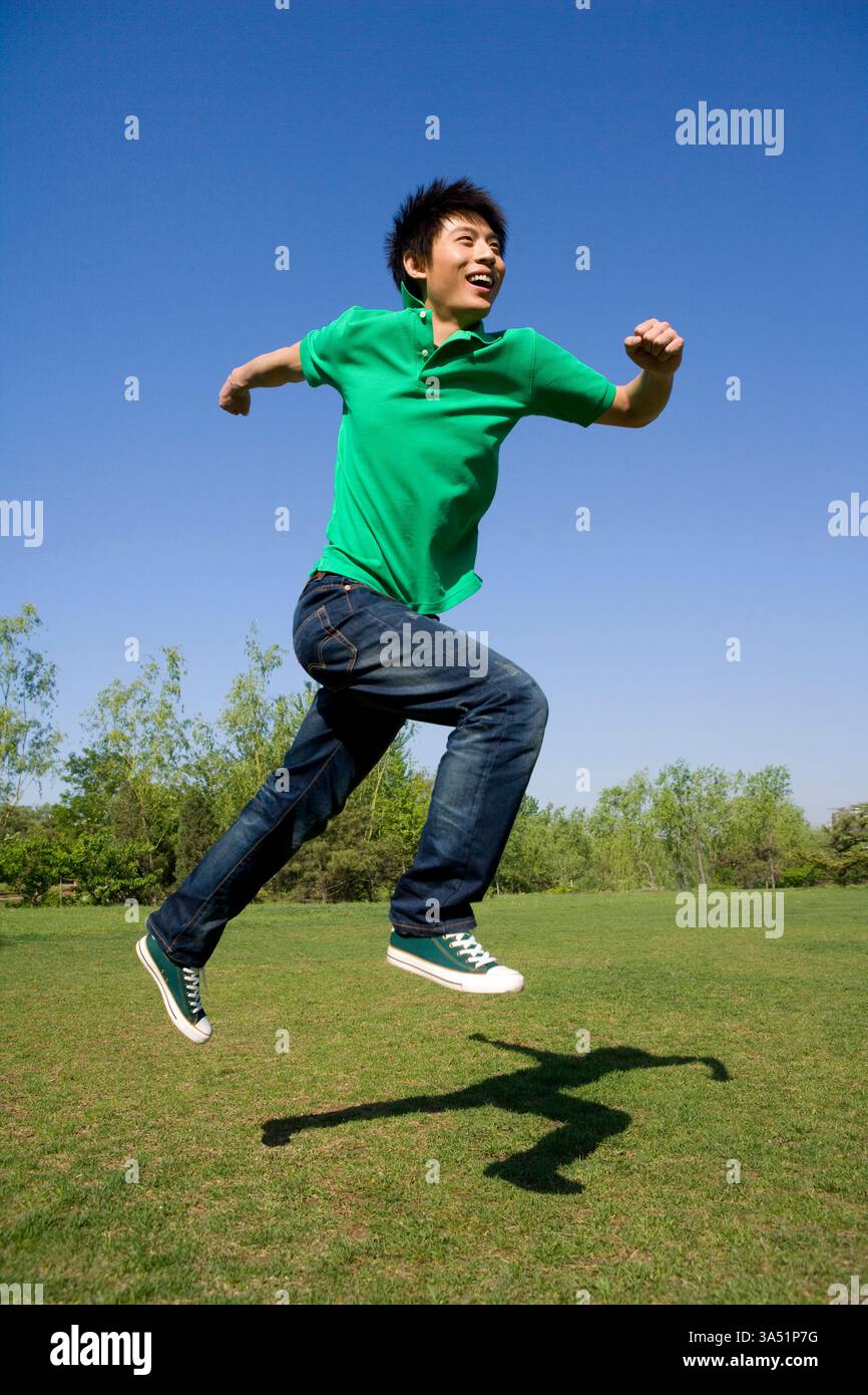 Young Chinese man jumping in air at park Stock Photo - Alamy