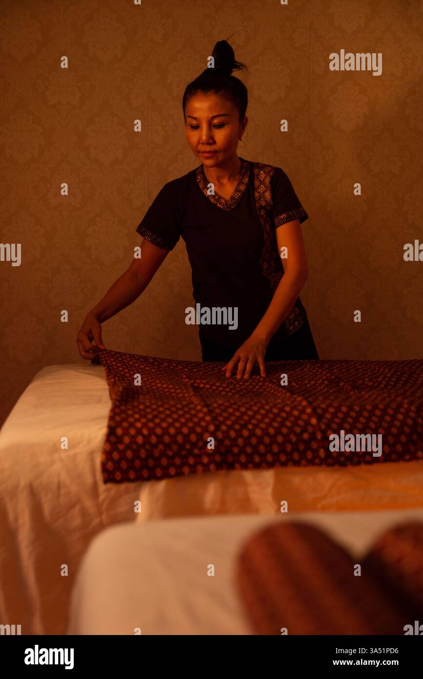 Asian woman in traditional clothes working in a thai massage salon ...