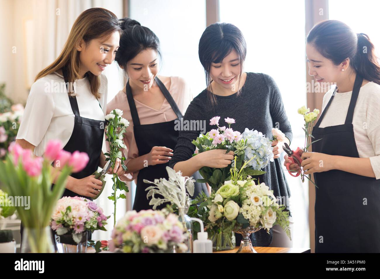 Chinese female teacher teaching women how to arrange flowers in ...