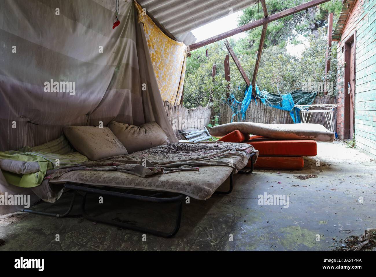 A weathered sleeping area in an abandoned shack, featuring old rusting ...