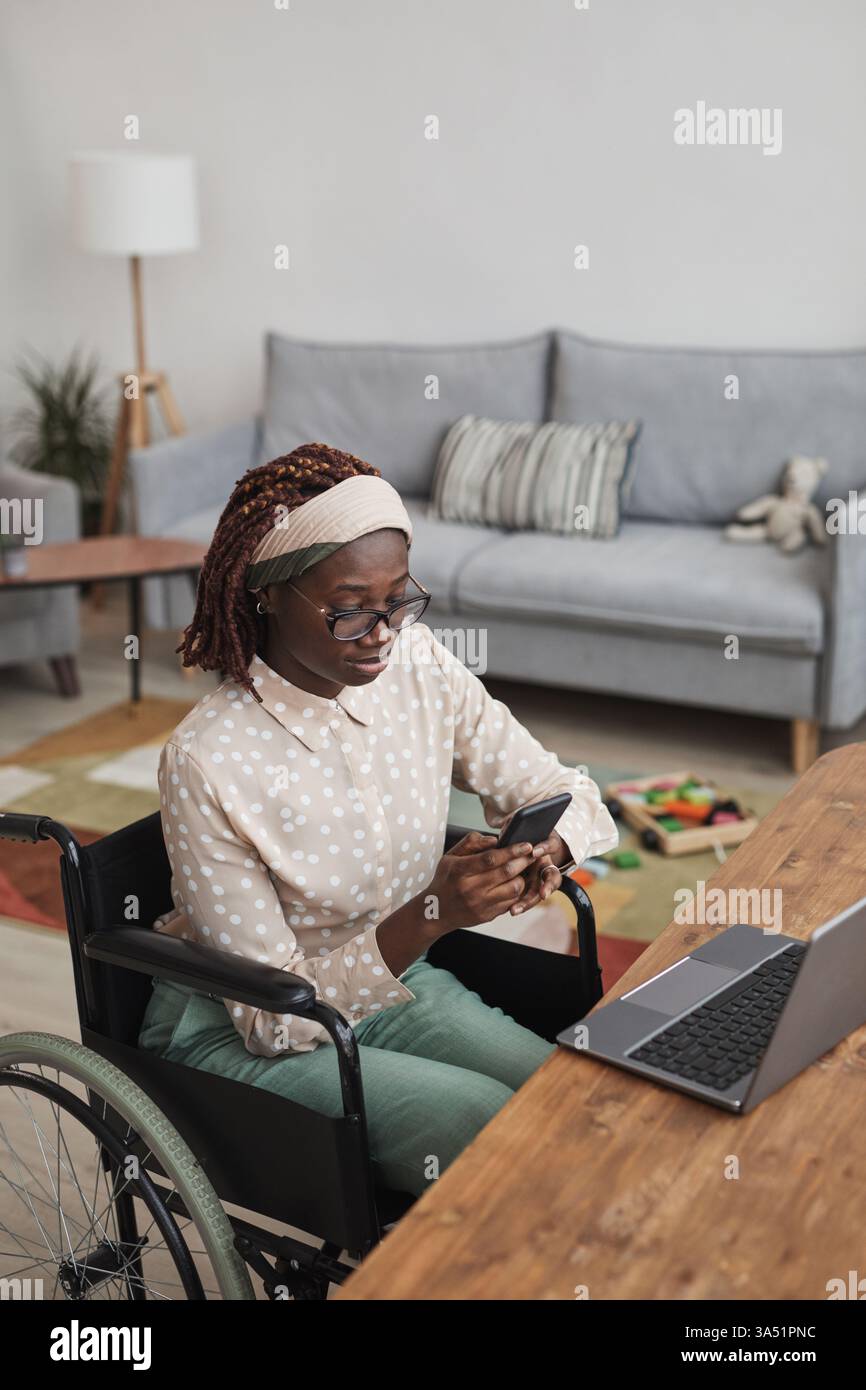 Vertical high angle portrait of Black woman using wheelchair while ...