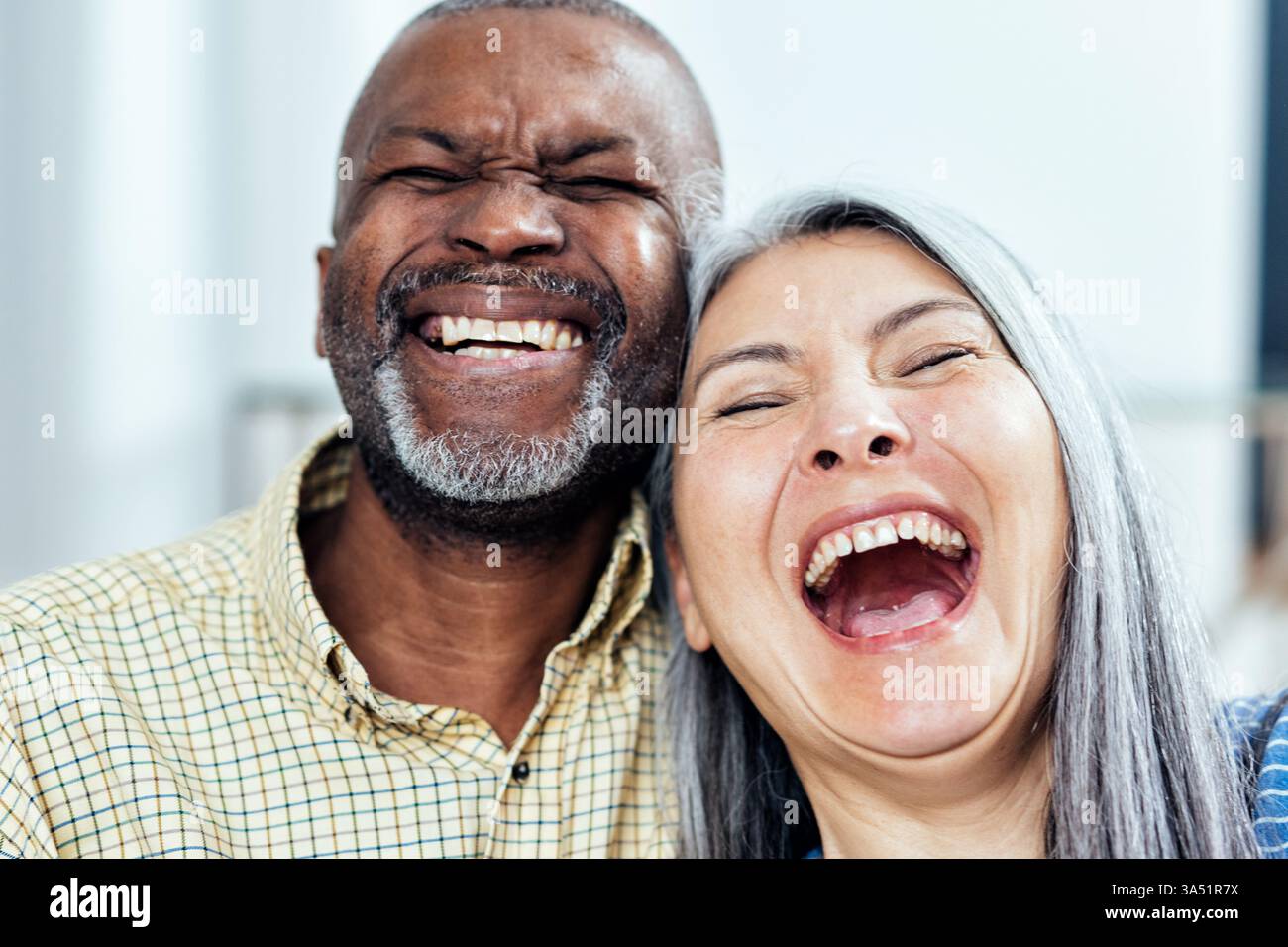 cinematic image of an happy multiethnic senior couple. Indoors ...