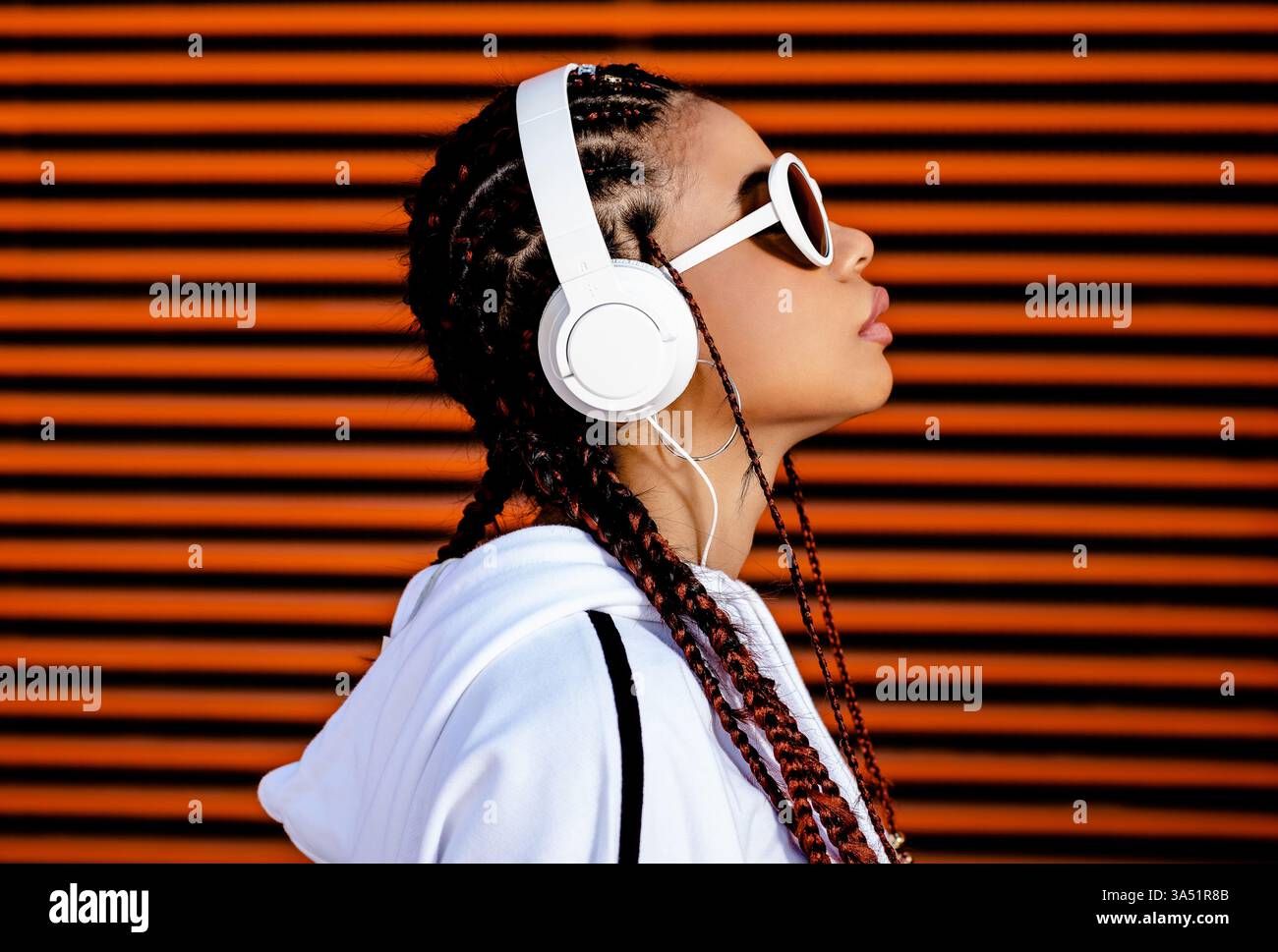African America woman in headphones and sunglasses standing sideways ...