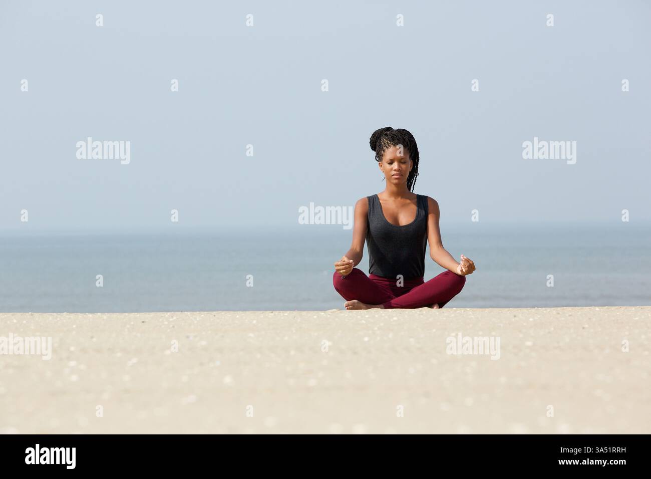 Portrait of an African woman practicing yoga on the beach. The calm ...