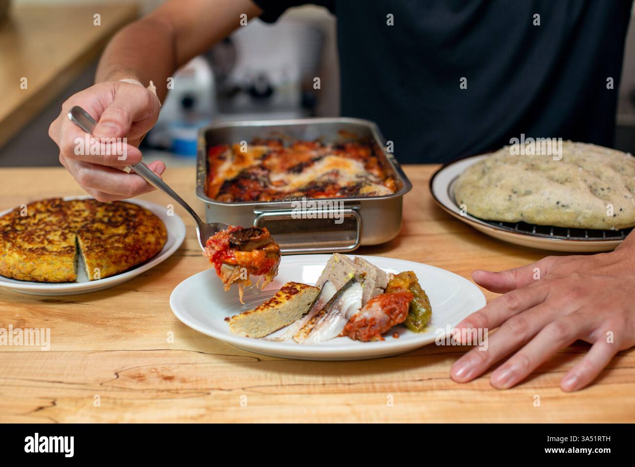 A man preparing dishes, plates of Italian food, on a restaurant pass ...