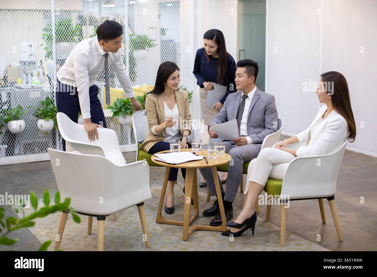 Chinese business people hold a meeting in a modern office ...