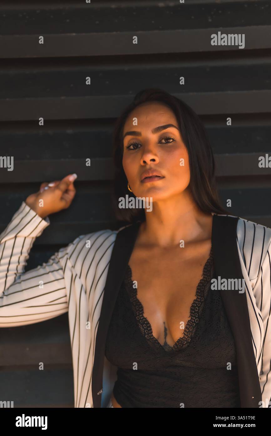 Lifestyle, straight-haired Latin brunette girl in a white suit and ...