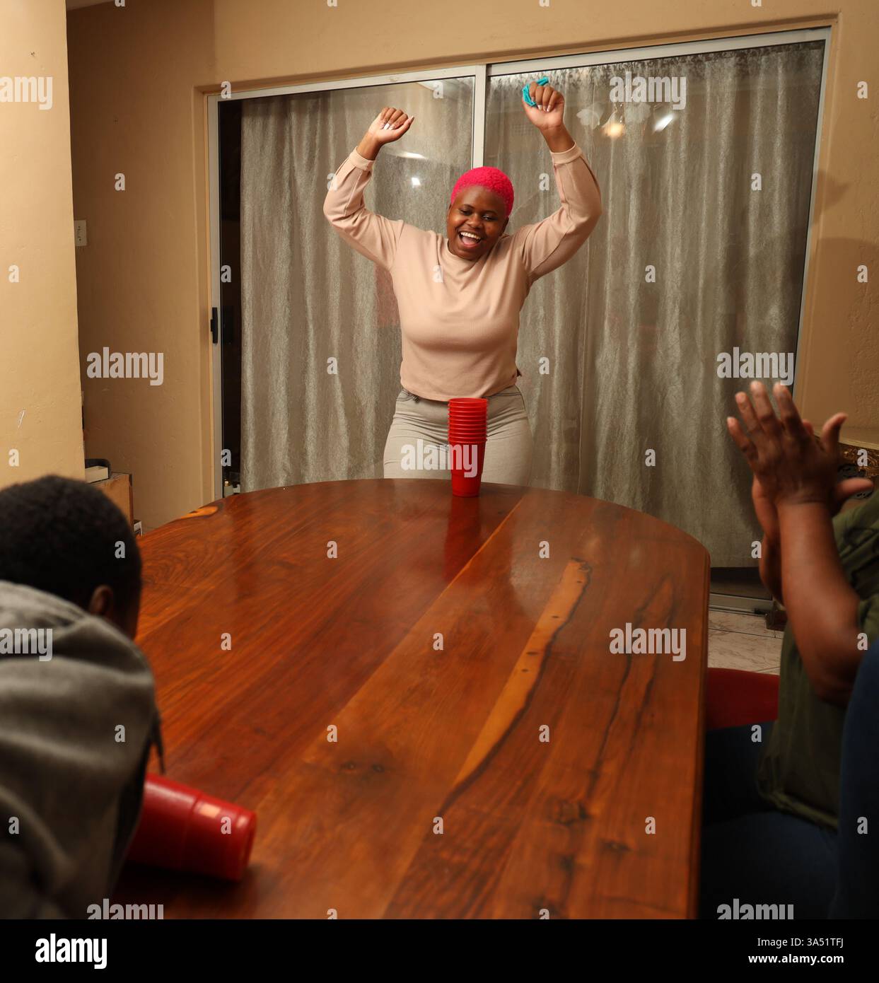 Cheerful Black female teenager with pink hair having fun playing ...