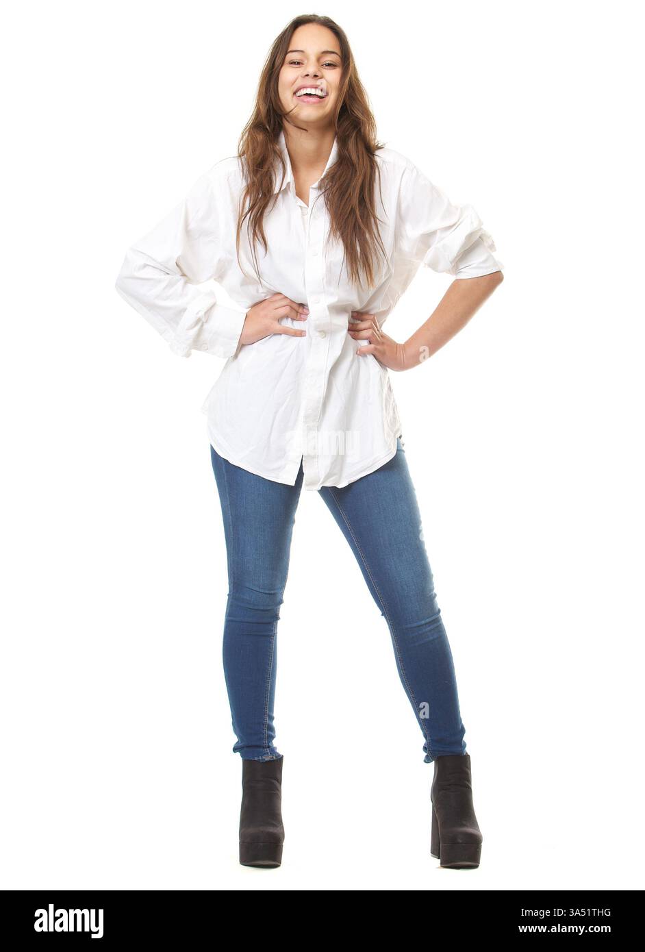 Smiling Mixed race woman with hands on waist standing with one legs ...