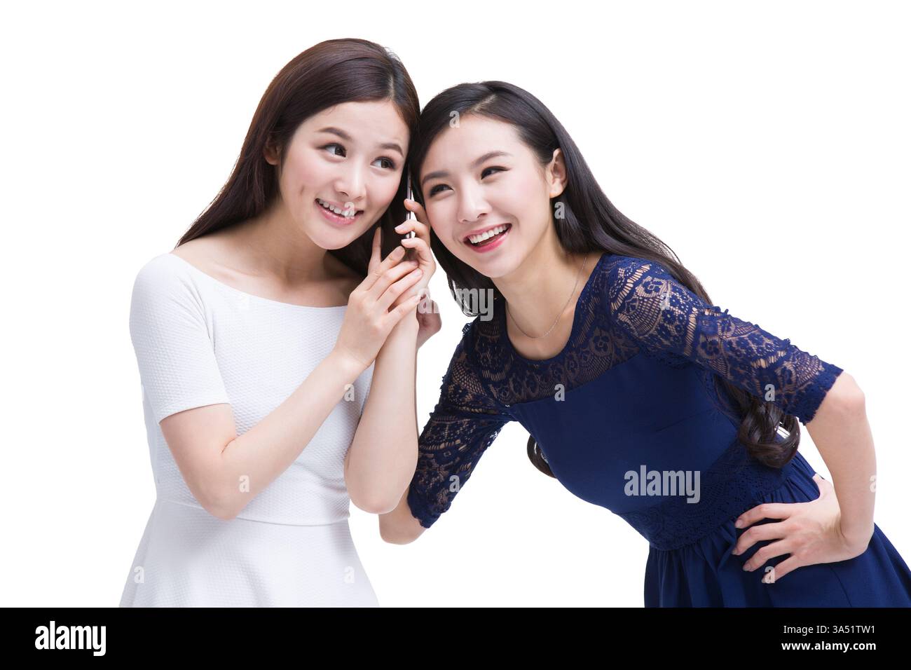 Female Chinese friends listening to phone together Stock Photo - Alamy