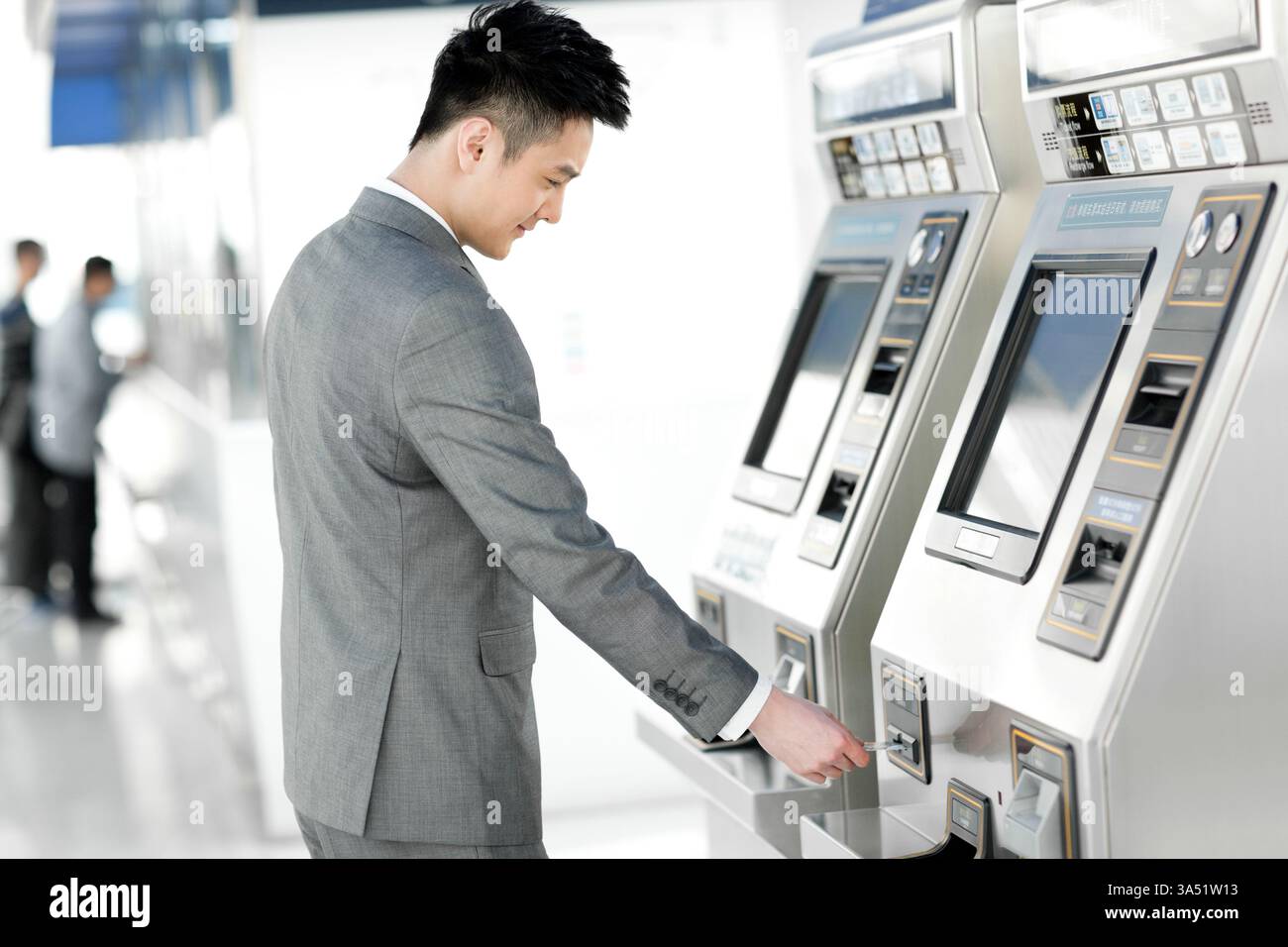 Chinese businessman using automatic ticket machine in subway station ...