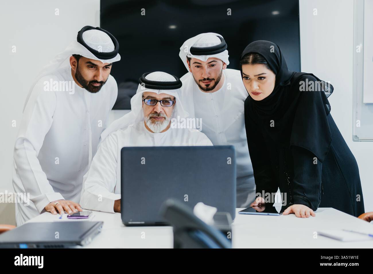 Smiling Middle Eastern businessmen wearing kandura and Muslim business ...