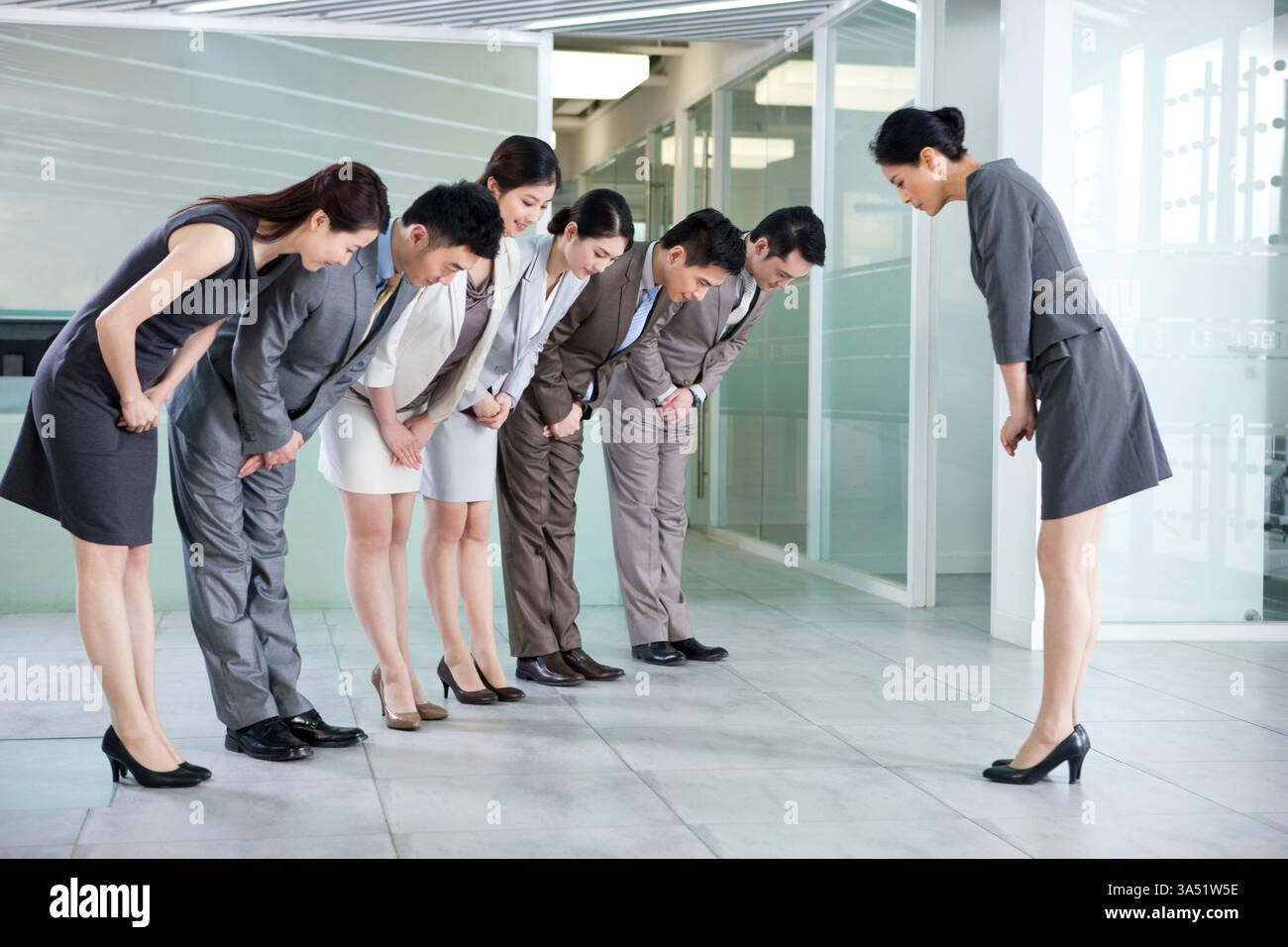Chinese business people and a middle-aged Chinese businesswoman bowing ...