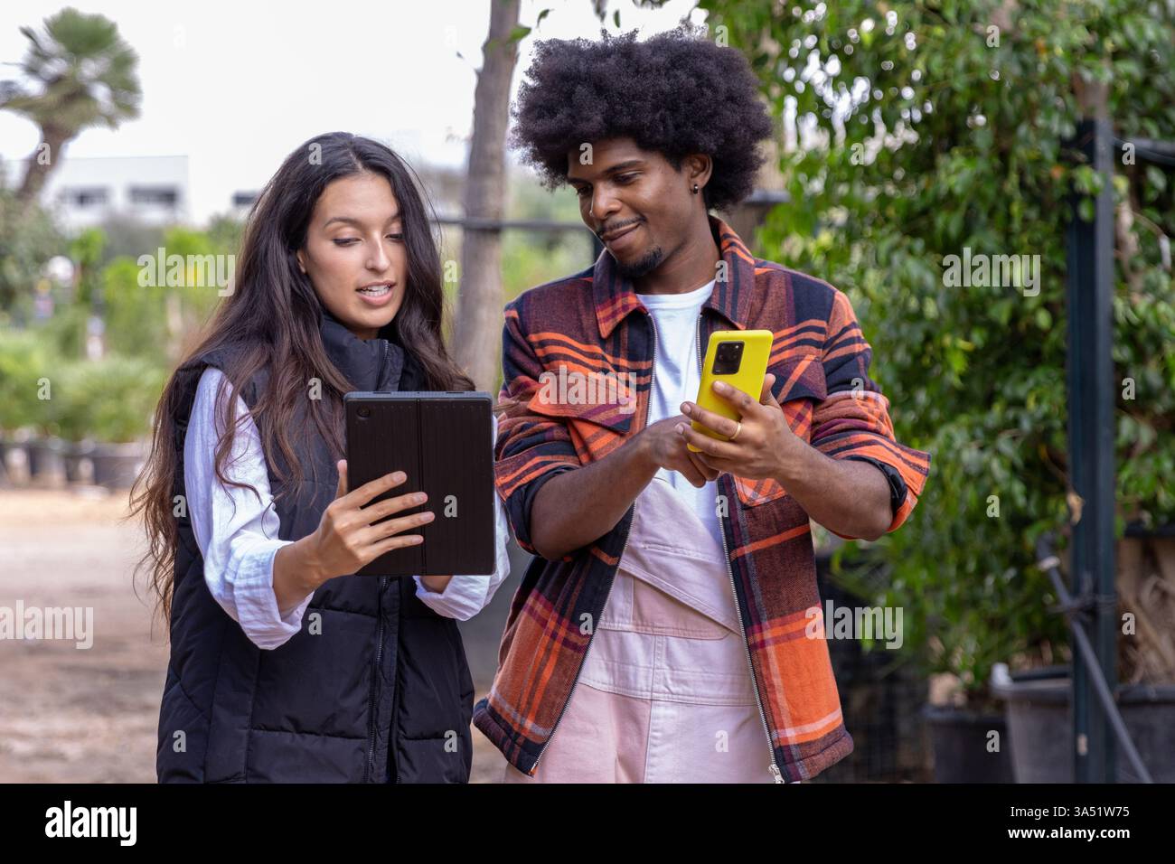 Young multiracial agronomists sharing ideas with wireless devices at an ...