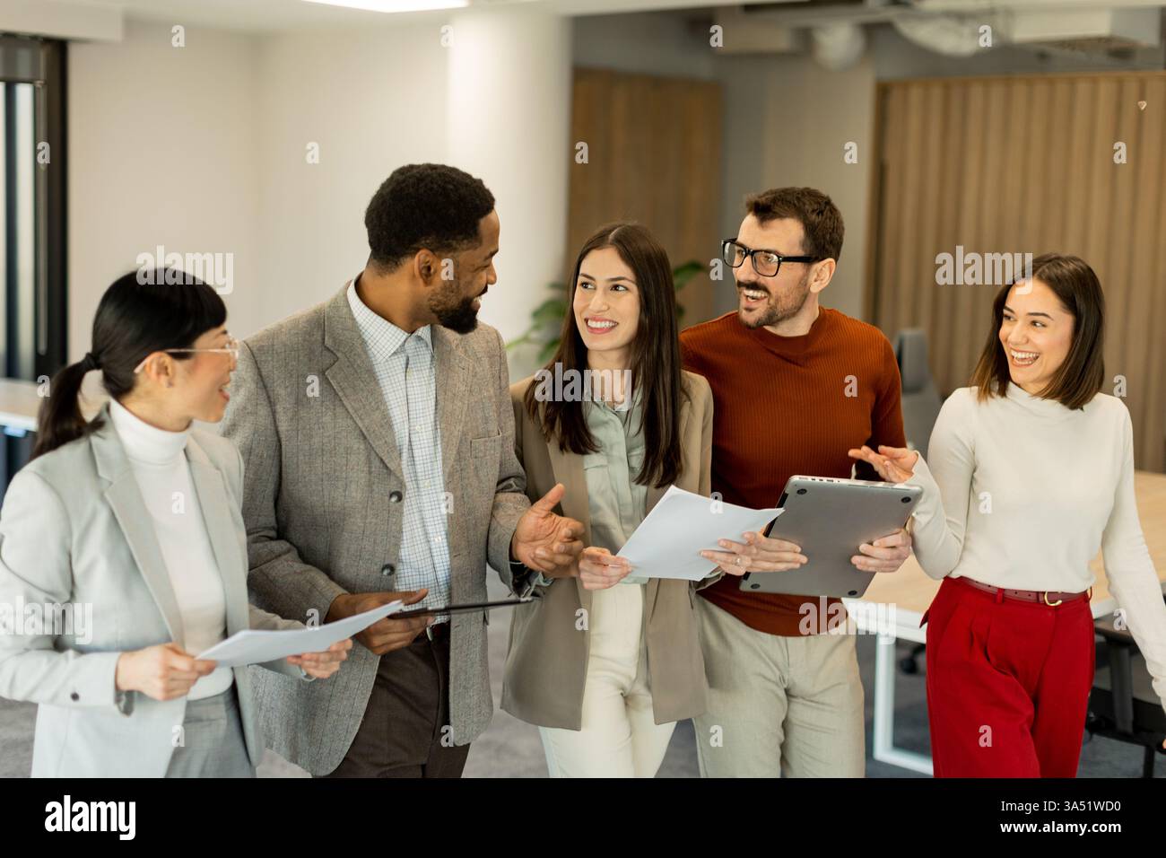 A group of professionals engages in lively discussions while reviewing ...