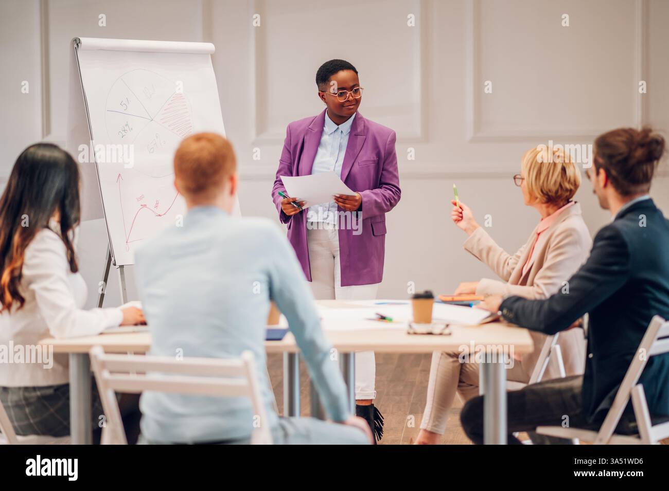 Black female business project leader presenting sales report to team on ...