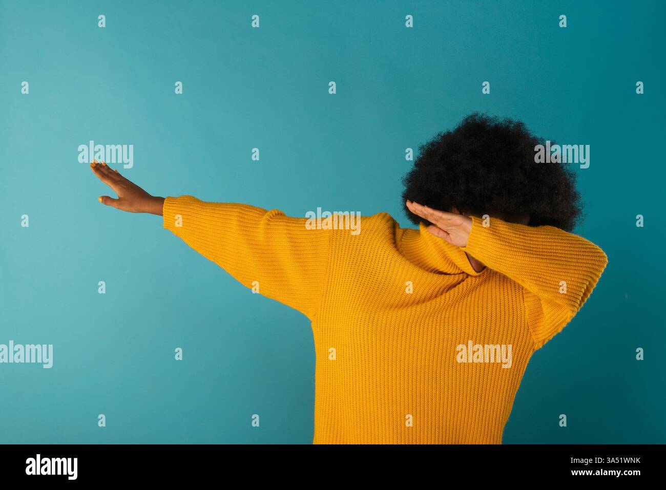 Black woman woman with afro hairstyle dabbing while standing against ...