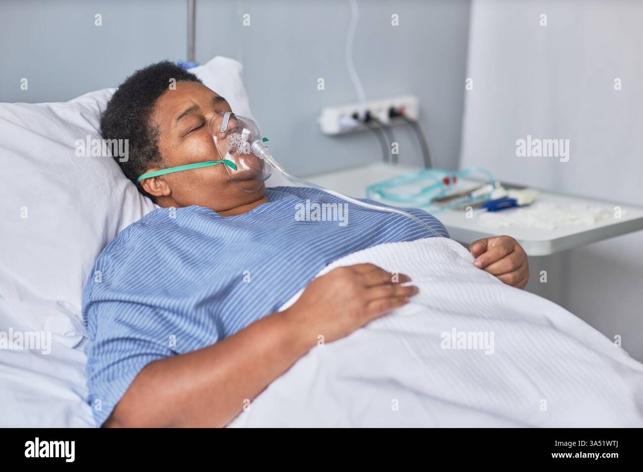 Portrait of black senior woman laying on bed in hospital room with ...