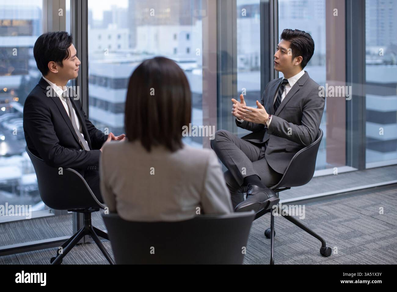 Chinese businessmen sitting facing each other having meeting with ...