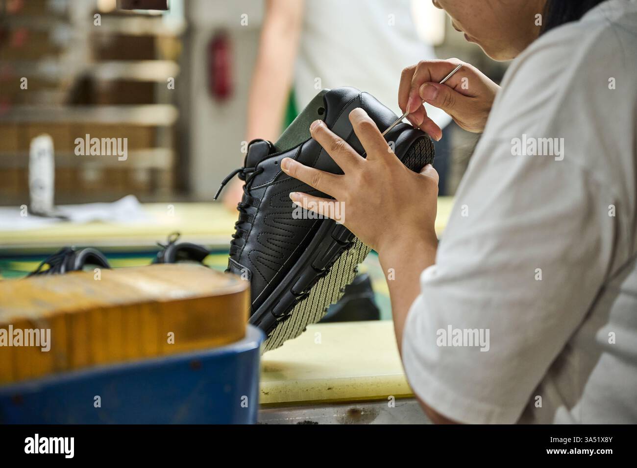 Asian female worker checking shoes quality in factory Stock Photo - Alamy