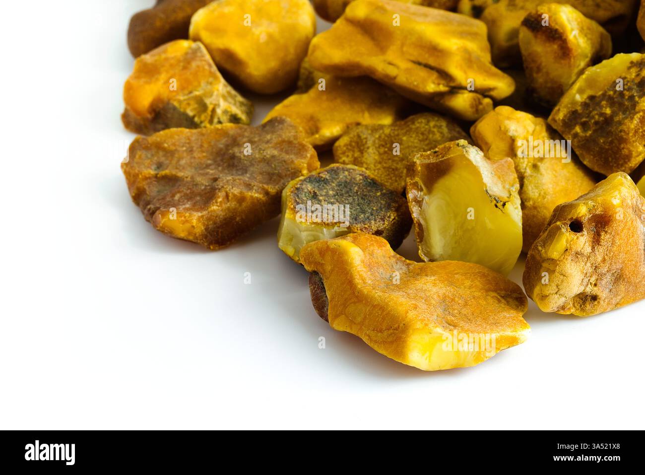 A detailed view of raw Polish Baltic amber on white reveals its rugged ...