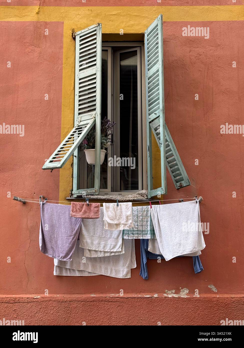 Laundry hanging outside a window with open shutters Stock Photo - Alamy