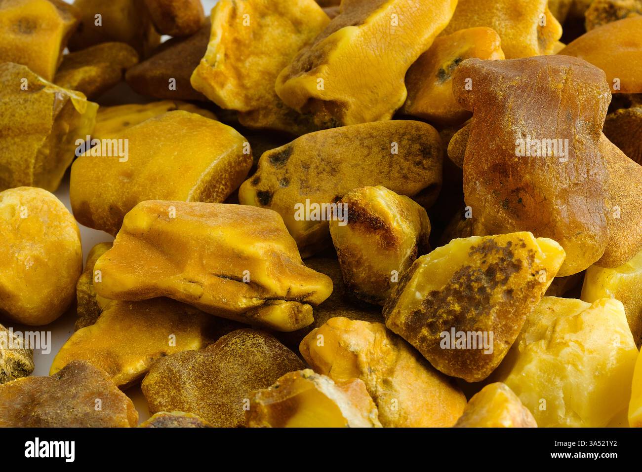 On a pristine white background, raw Polish Baltic amber is arranged ...